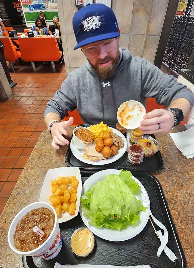 One happy customer contemplates multiple trays of food, which is basically the standard operating procedure at this legendary spot.