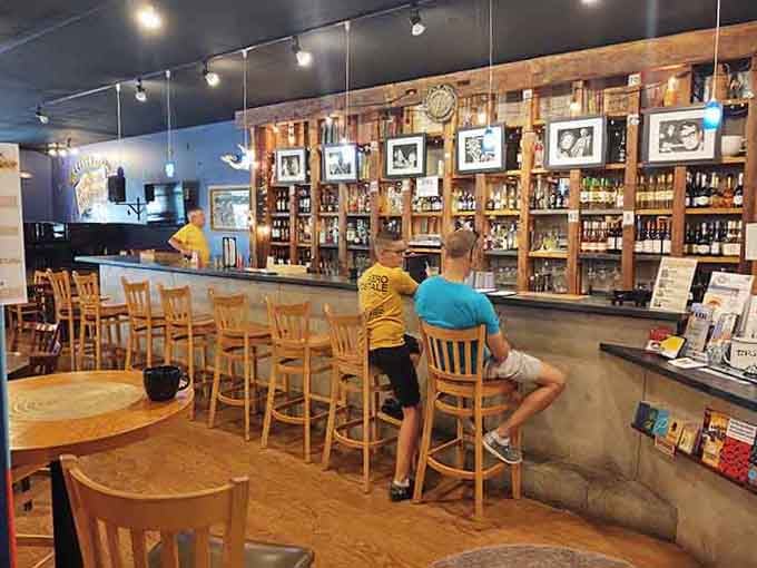 The bar stretches invitingly along rustic shelving, where wine bottles stand ready to enhance your next chapter beautifully.