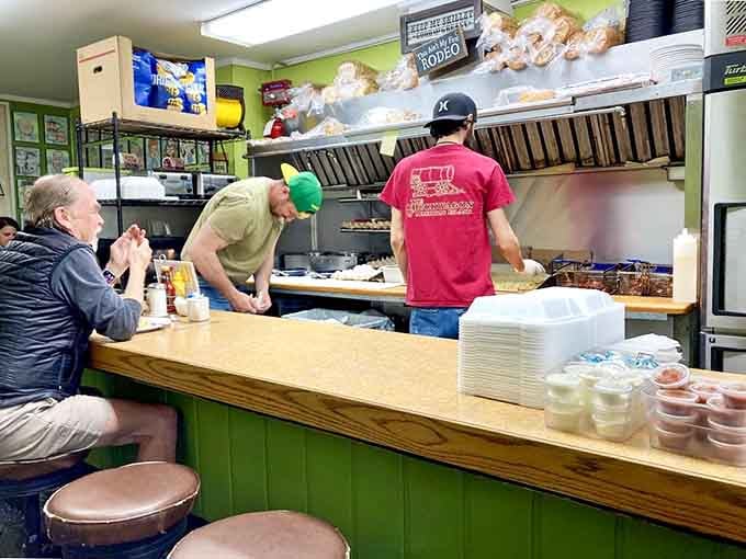 The kitchen crew working their magic in tight quarters, turning out creative burgers with impressive speed and precision throughout.
