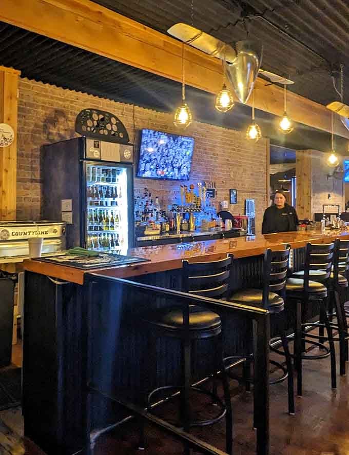The bar area features exposed brick and Edison bulbs creating ambiance that's both rustic and surprisingly sophisticated.