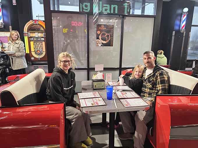Happy diners enjoying their meal in a classic car booth proves this place delivers on its promise.