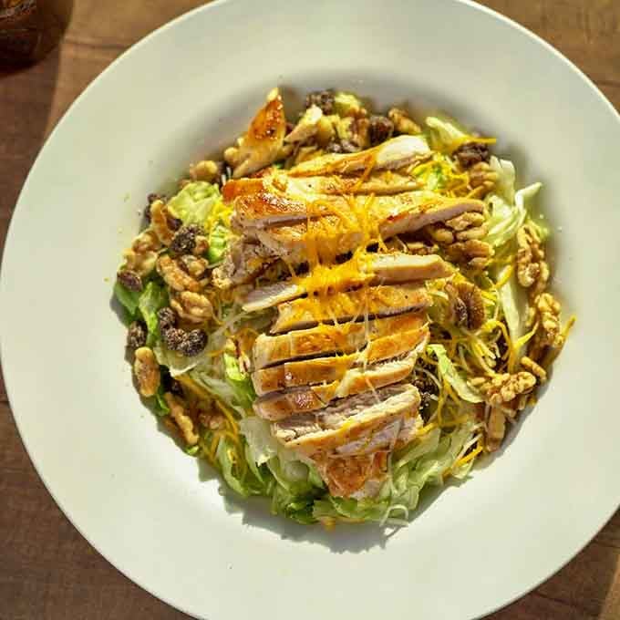 This salad topped with grilled chicken, walnuts, and cheese proves healthy eating doesn't mean sacrificing flavor or satisfaction.