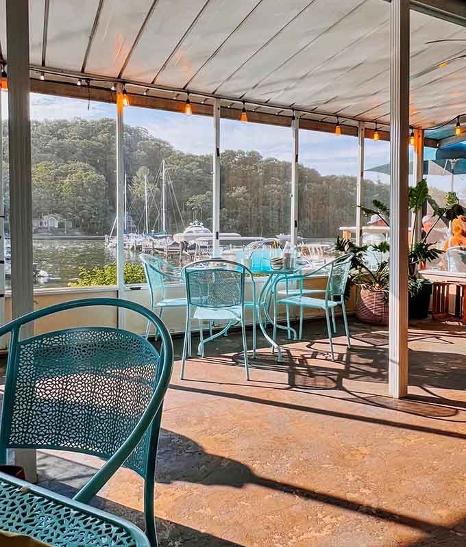 The covered patio with turquoise chairs overlooks the water, combining lakeside views with Southern comfort food perfectly.