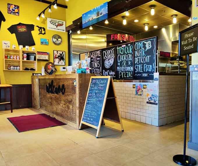 The welcoming host station greets you with a chalkboard menu that promises fresh-made Detroit-style pizza awaits inside.