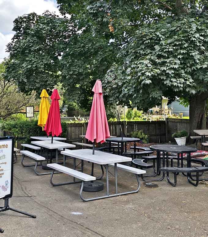 Outdoor picnic tables under colorful umbrellas turn a quick lunch into a proper al fresco dining experience.