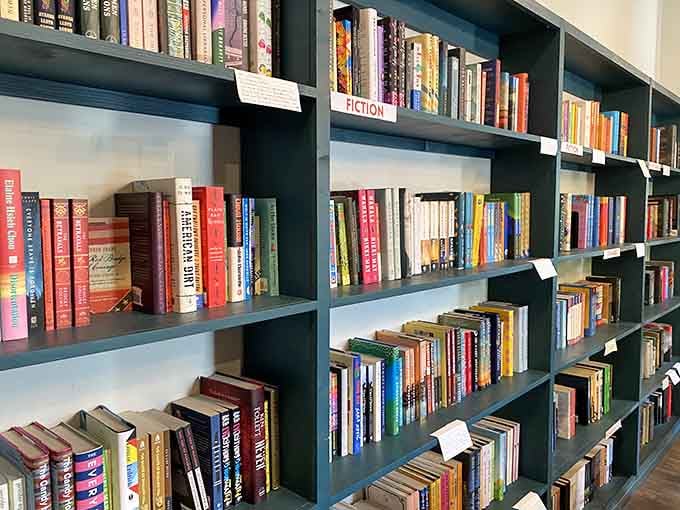 Fiction shelves organized and inviting, ready to transport you anywhere from your cozy reading chair nearby.