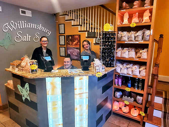 Friendly staff members welcome visitors at the backlit reception desk, ready to guide you through your salt therapy adventure.