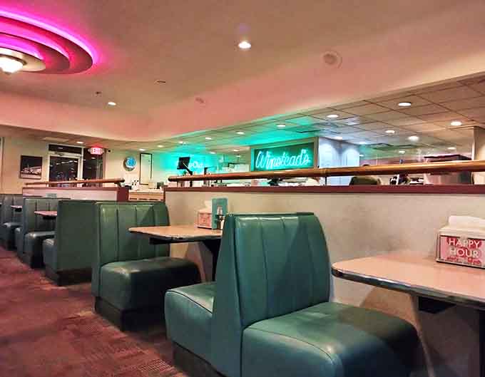 More of those gorgeous teal booths stretching across the dining room, each one a portal to simpler, more delicious times.