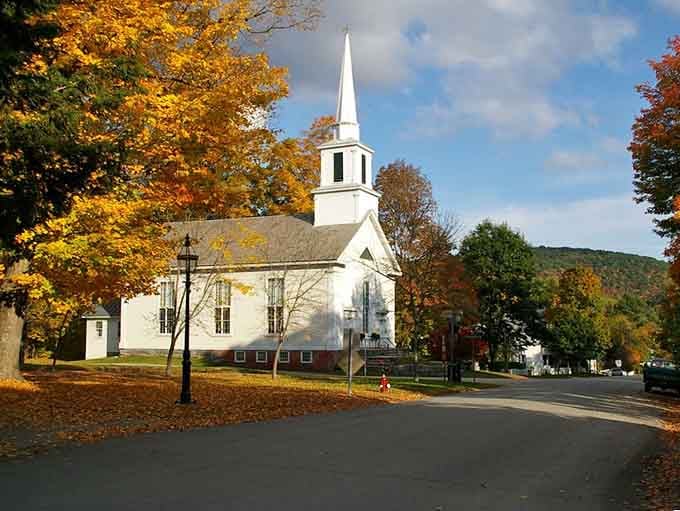 A white steeple church surrounded by fall colors looks like Norman Rockwell himself painted it just for this very moment.