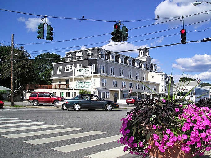 Mansard roofs and dormer windows top this substantial building where flowers add cheerful pops of color.