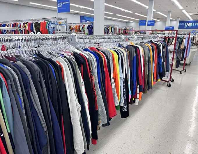 Long sleeve shirts organized by color like a rainbow decided to become a clothing section and succeeded brilliantly.