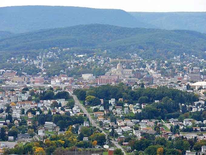 The aerial view reveals a real city nestled in real mountains, not some flat suburban sprawl pretending.