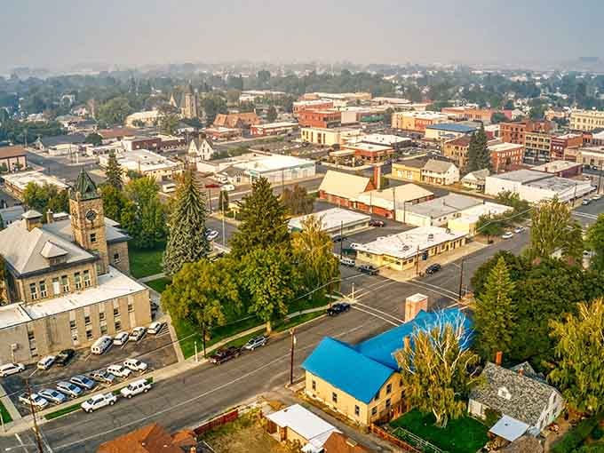 Aerial views reveal a compact, walkable town surrounded by mountains, basically the opposite of sprawling suburban nightmares everywhere.