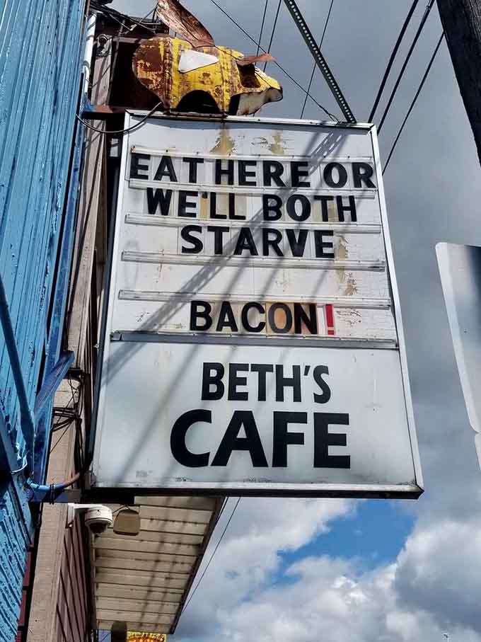A sign that perfectly captures the diner's no-nonsense philosophy: eat here or starve, preferably with bacon involved.