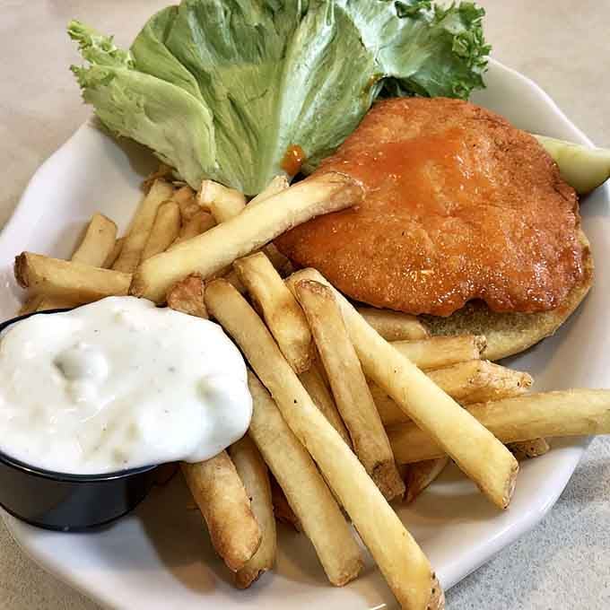 Buffalo chicken sandwich with fries proving that sometimes the simple pleasures are actually the most satisfying ones.