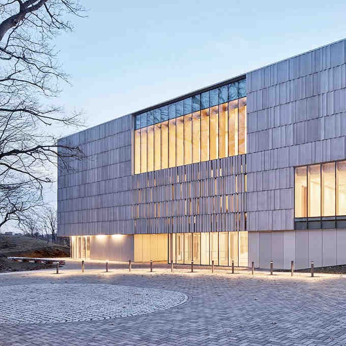 The building's contemporary design glows invitingly at dusk, beckoning culture seekers from near and far to explore within.