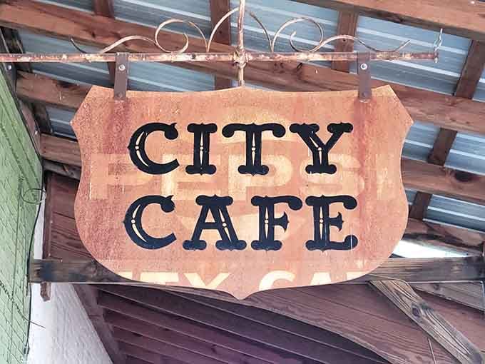 The City Cafe sign hanging proud, a beacon calling hungry souls to breakfast salvation in downtown Northport, Alabama.