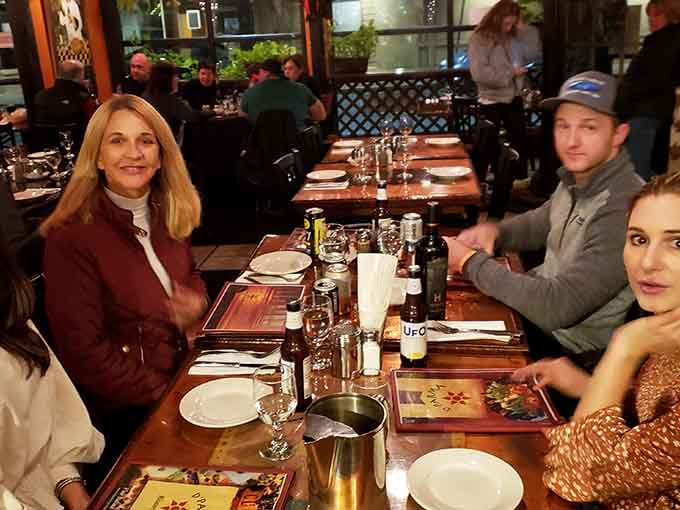 Happy diners around the table prove that great Italian food brings people together like nothing else can.