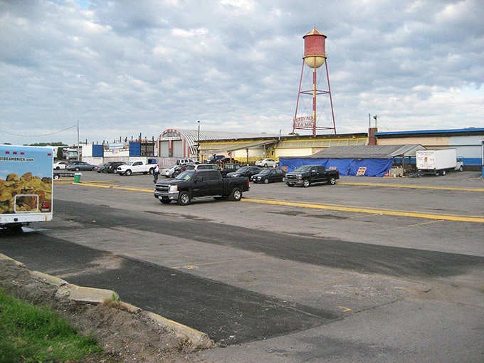 The sprawling parking area and iconic water tower backdrop frame a marketplace where Louisville comes to shop, socialize, and score deals.