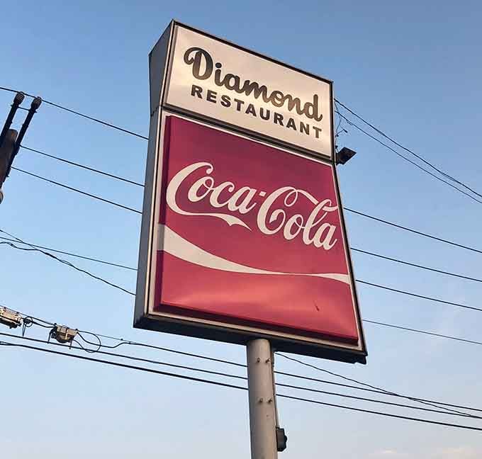 The vintage Coca-Cola sign standing tall like a beacon guiding hungry travelers to their delicious destiny since way back when.