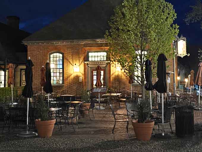 The building glows like a welcoming beacon at night, with that patio looking absolutely magical under the soft lighting and evening sky.