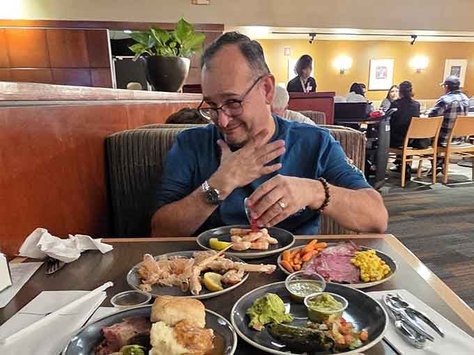 Happy diners surrounded by multiple plates demonstrate the buffet experience in action, living their best culinary life.