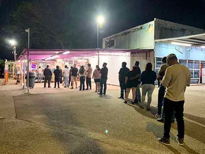 Evening crowds gathering under the lights like moths to a flame, except this flame serves incredible tacos.