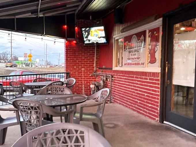 Outdoor seating with brick walls and TVs because why should inside diners have all the fun.