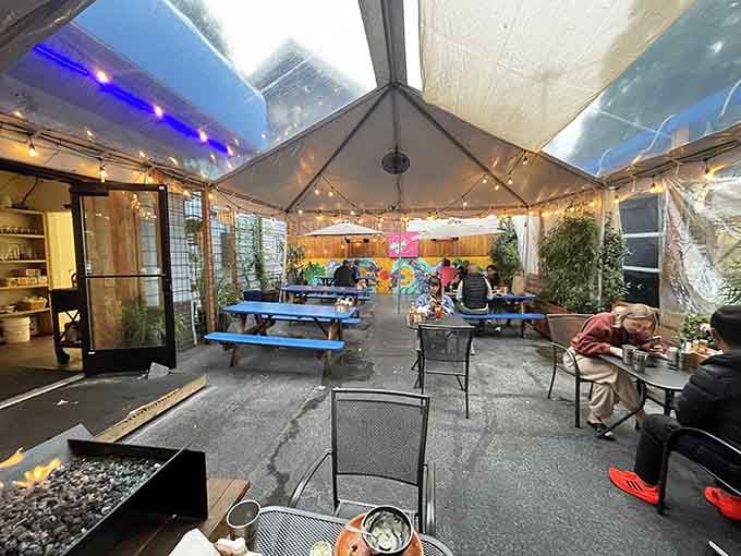 The covered patio with colorful murals transforms outdoor dining into an experience that feels like a permanent summer vacation.