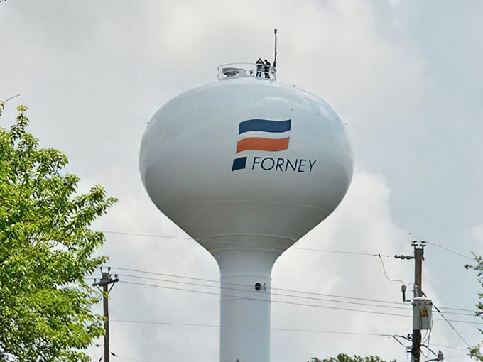 The iconic Forney water tower stands proud, marking your destination like a lighthouse for antique enthusiasts.