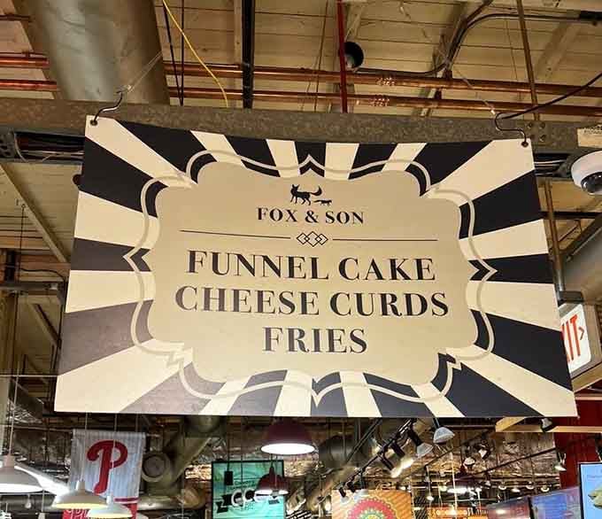 Bold signage announces the holy trinity of fair food done right: funnel cake, cheese curds, and hand-cut fries.