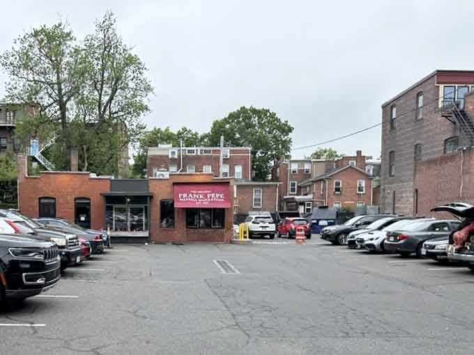 The parking lot view shows this humble exterior houses one of America's most celebrated pizza destinations inside those walls.