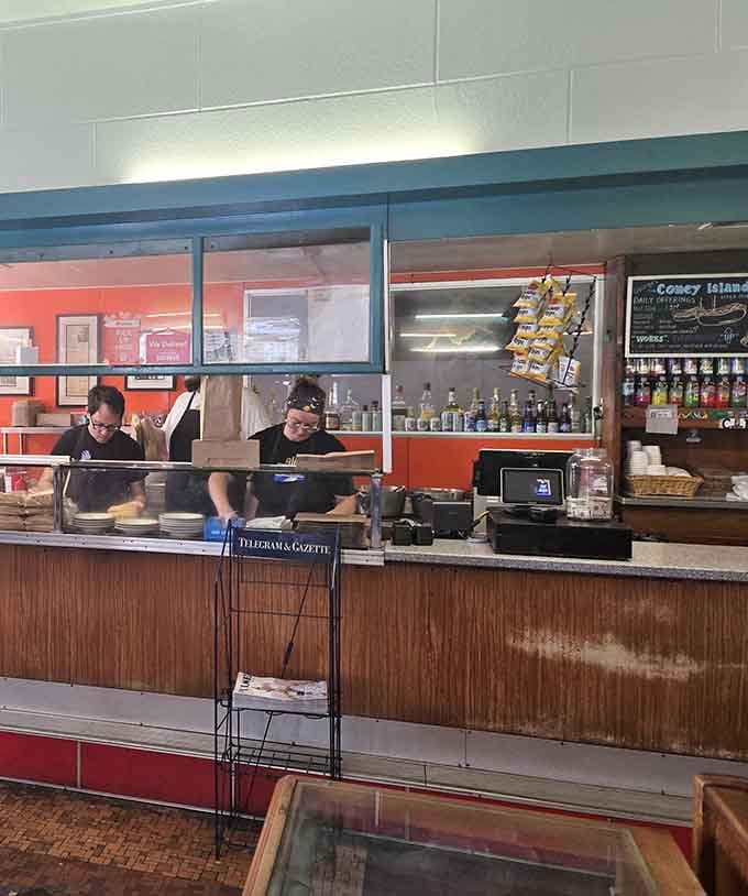 Behind the counter, the magic happens with the same efficiency and care that's defined this place for nearly a century.