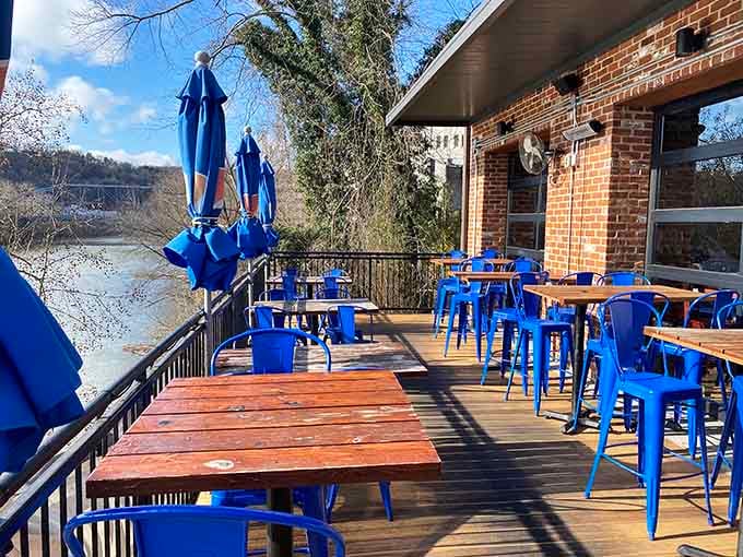The patio overlooking the river with those bright blue chairs is where good food meets even better views.