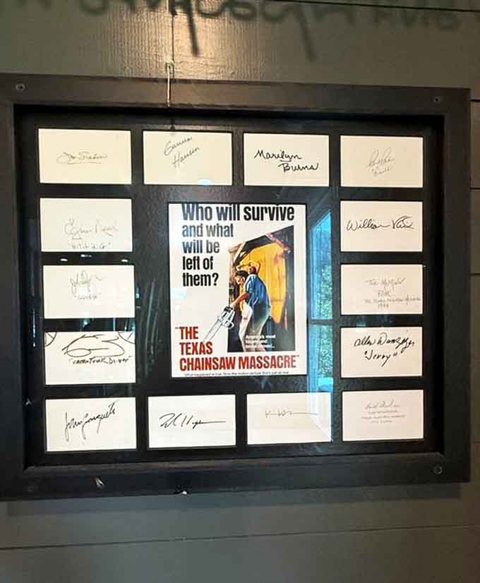 Framed horror memorabilia and cast signatures celebrate Texas's contribution to cinema, turning walls into conversation starters for movie buffs.