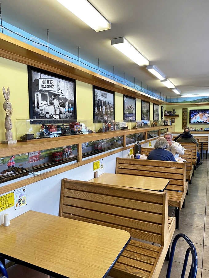Wooden booths line up beneath the train tracks, offering front-row seats to both culinary and locomotive excellence combined.