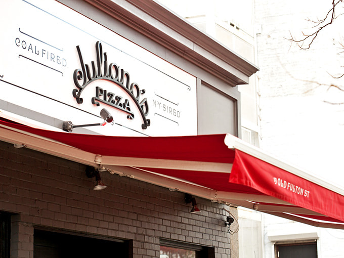 The hand-painted signage curves gracefully, announcing your destination with old-school Brooklyn charm and pride.