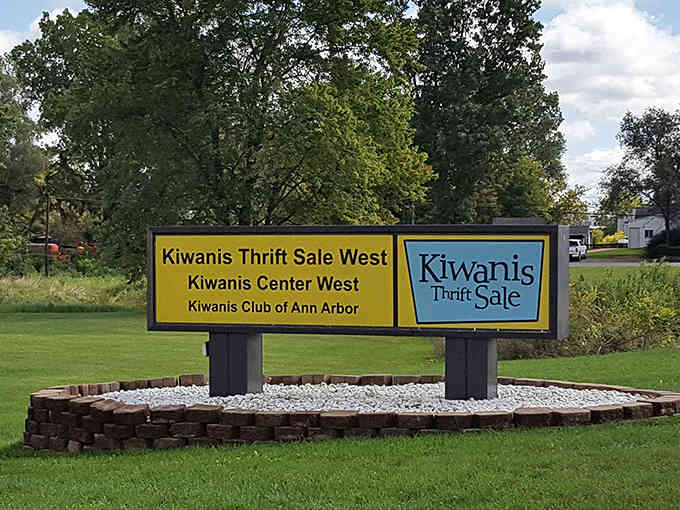 The roadside sign beckons bargain hunters like a lighthouse guides ships, promising treasures just beyond the parking lot.