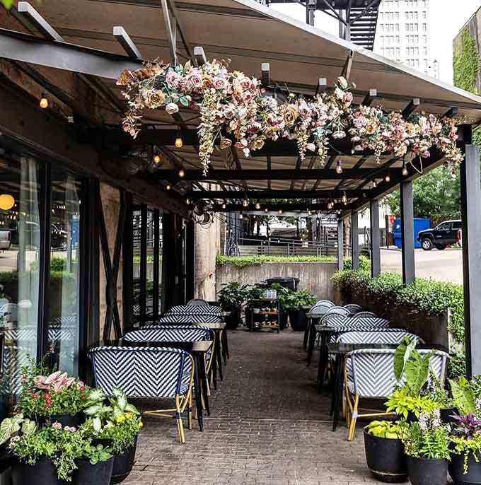 Cascading flowers overhead transform this patio into a secret garden where brunch dreams come true.