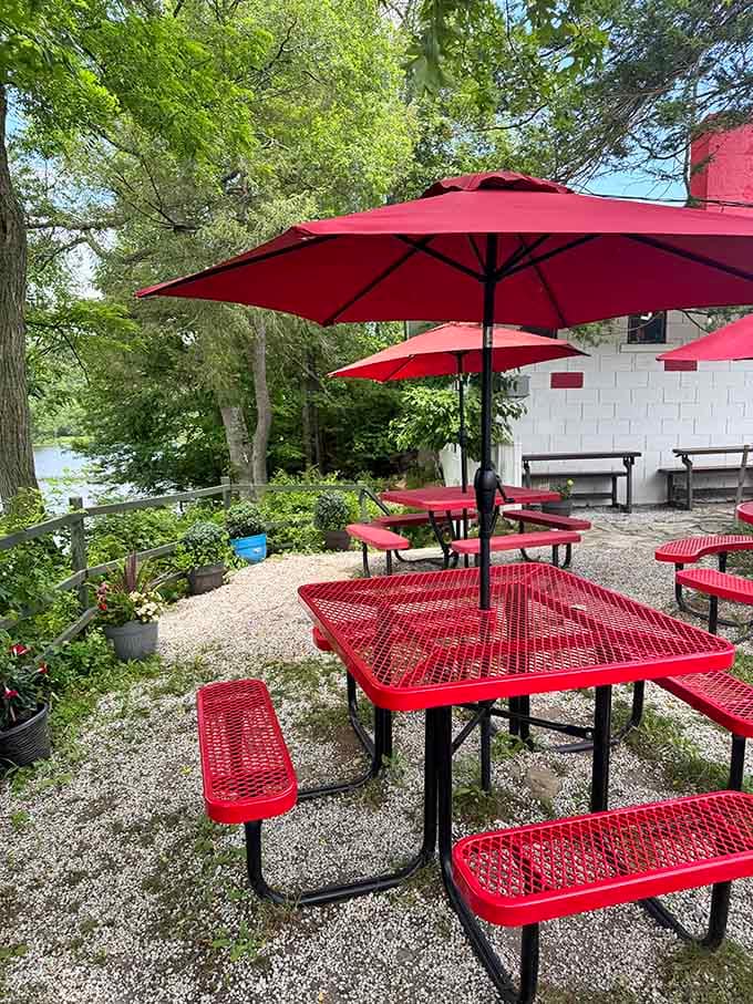 Lakeside outdoor seating with red umbrellas and water views&mdash;because sometimes breakfast tastes even better with fresh air.