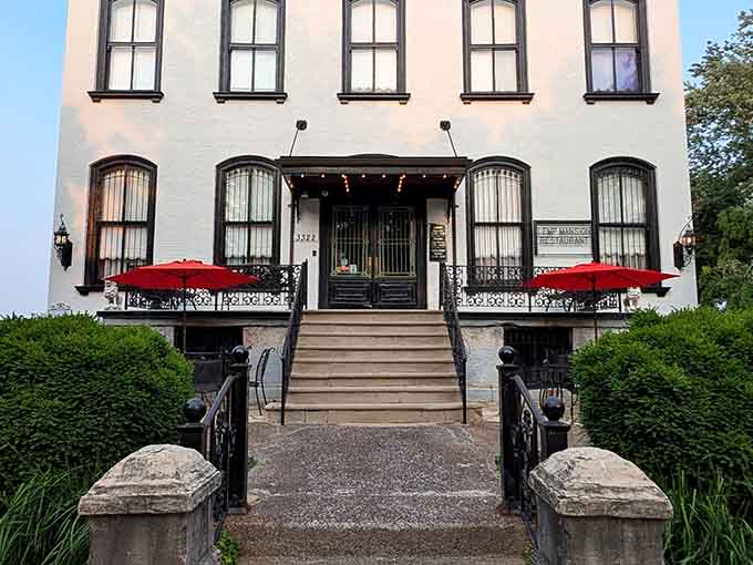 The grand entrance welcomes guests with ornate ironwork and red umbrellas, setting expectations appropriately sky-high.