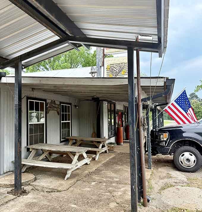 Outdoor seating with picnic tables and an American flag&mdash;because sometimes the best meals happen under the Texas sky itself.
