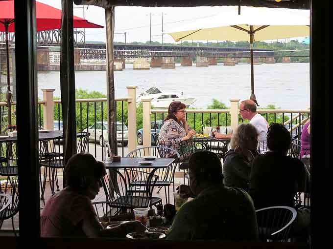 River views framed by open windows while diners enjoy their meals, because the best sauce is always a beautiful vista.