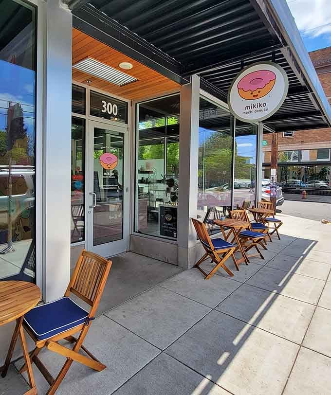 Wooden chairs with blue cushions wait patiently outside, ready to host your next alfresco donut date with destiny.