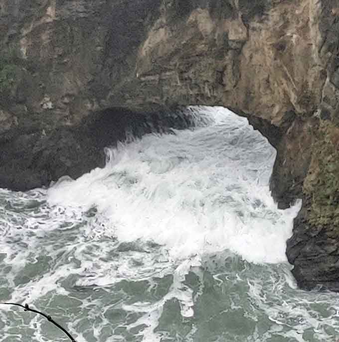 Waves surge through the natural arch with the kind of power that makes you respect the ocean's strength.