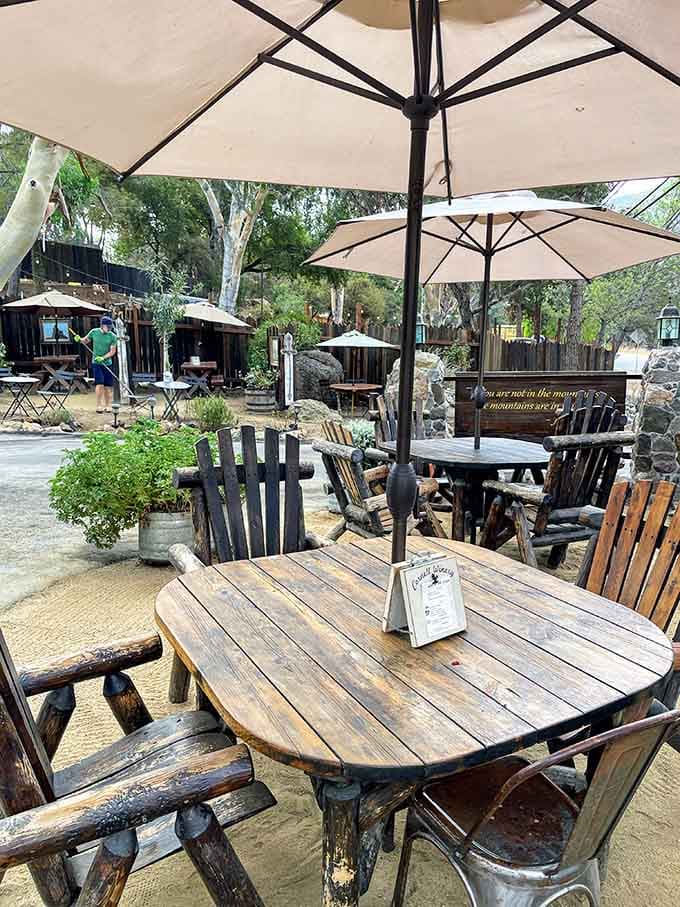 Umbrellas and handcrafted wooden tables create an outdoor oasis where time slows down and worries fade away completely.