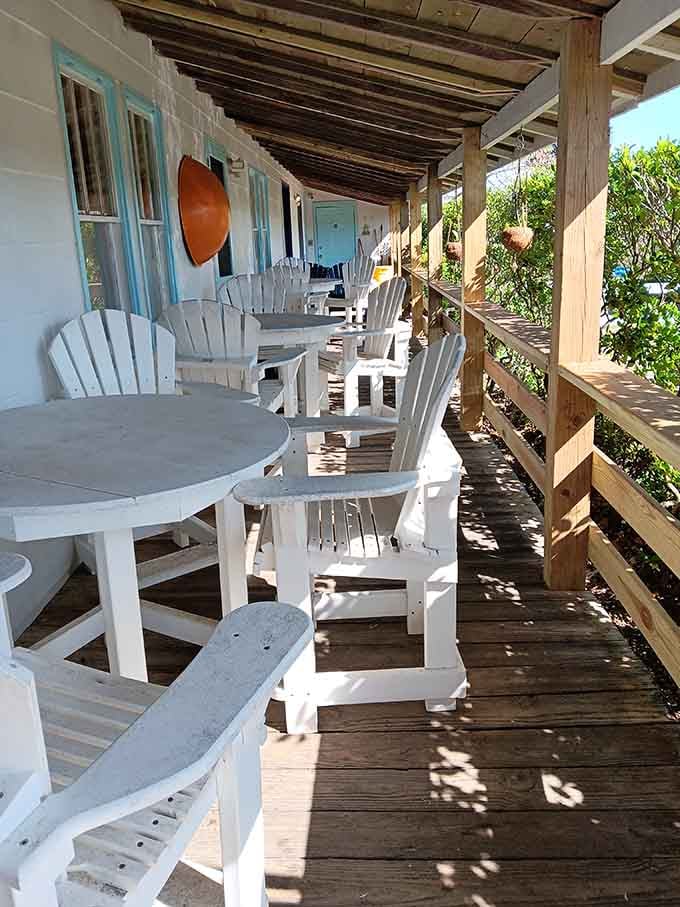 White Adirondack chairs lined up on the shaded porch, the perfect spot for enjoying your spoils while planning nothing.