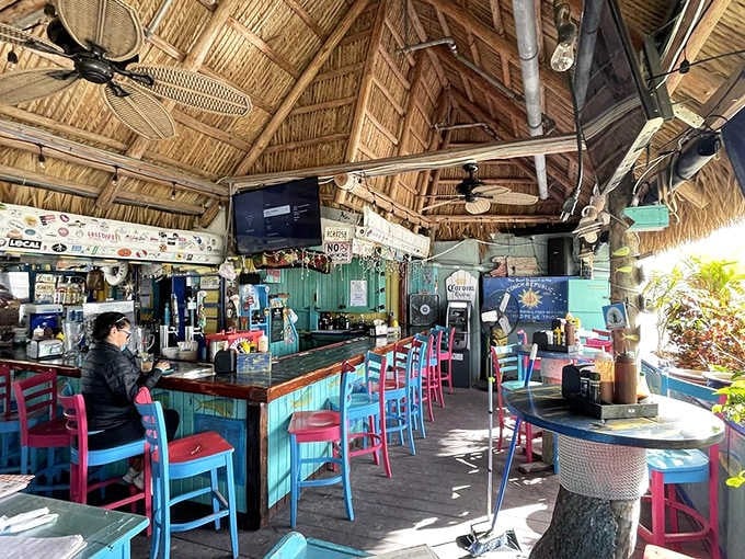 The turquoise bar stools and thatched ceiling create an atmosphere where Jimmy Buffett songs play on endless loop.