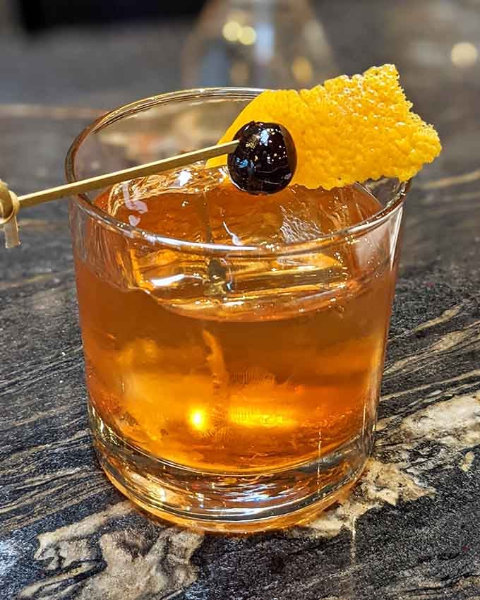 A Manhattan cocktail garnished with honeycomb, because Rocco's knows how to elevate the classics with style.