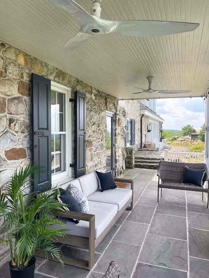 Stone walls meeting comfortable seating on a patio that understands the assignment of outdoor living spaces perfectly